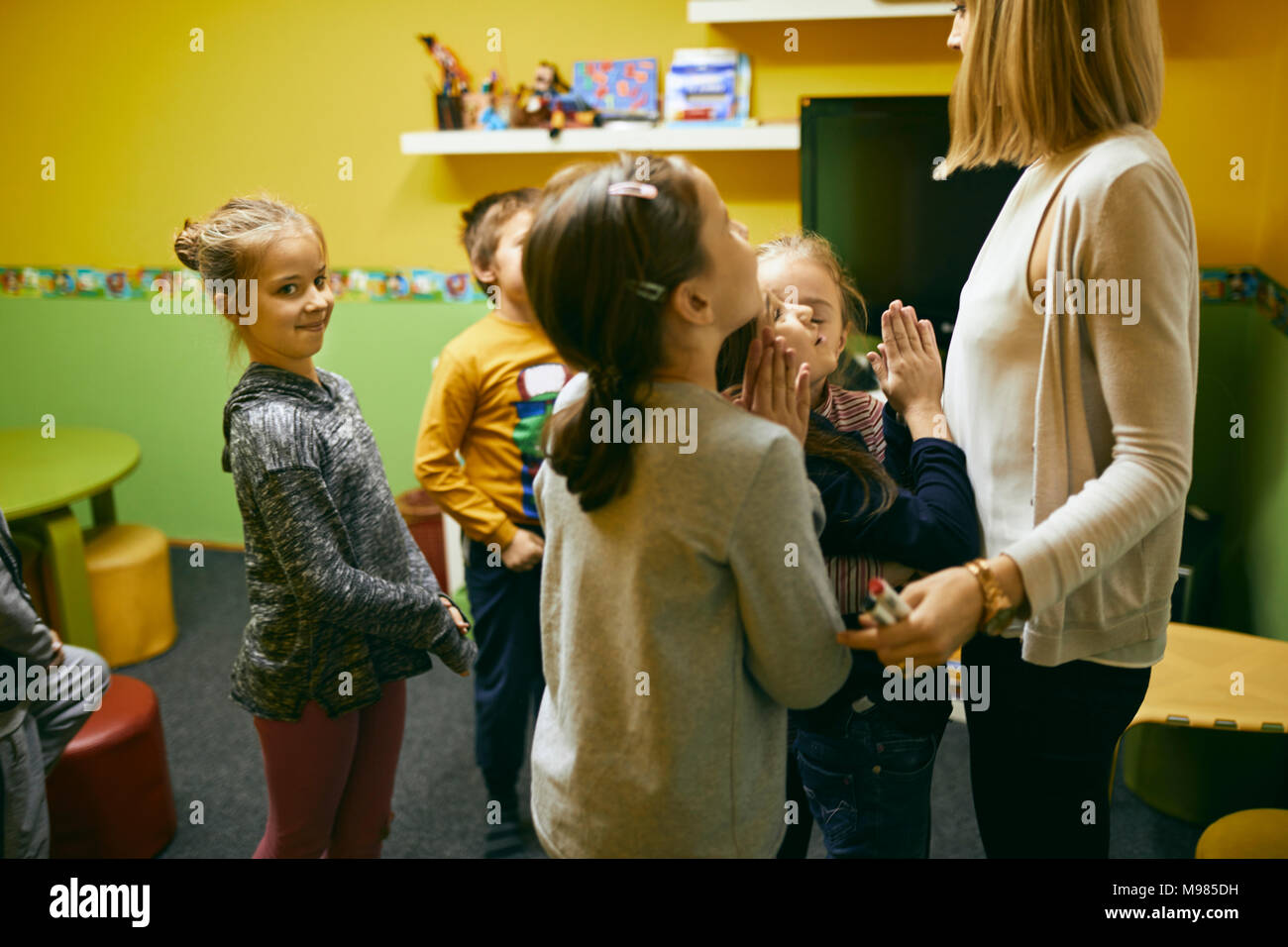 Teacher standing with students in class Stock Photo - Alamy