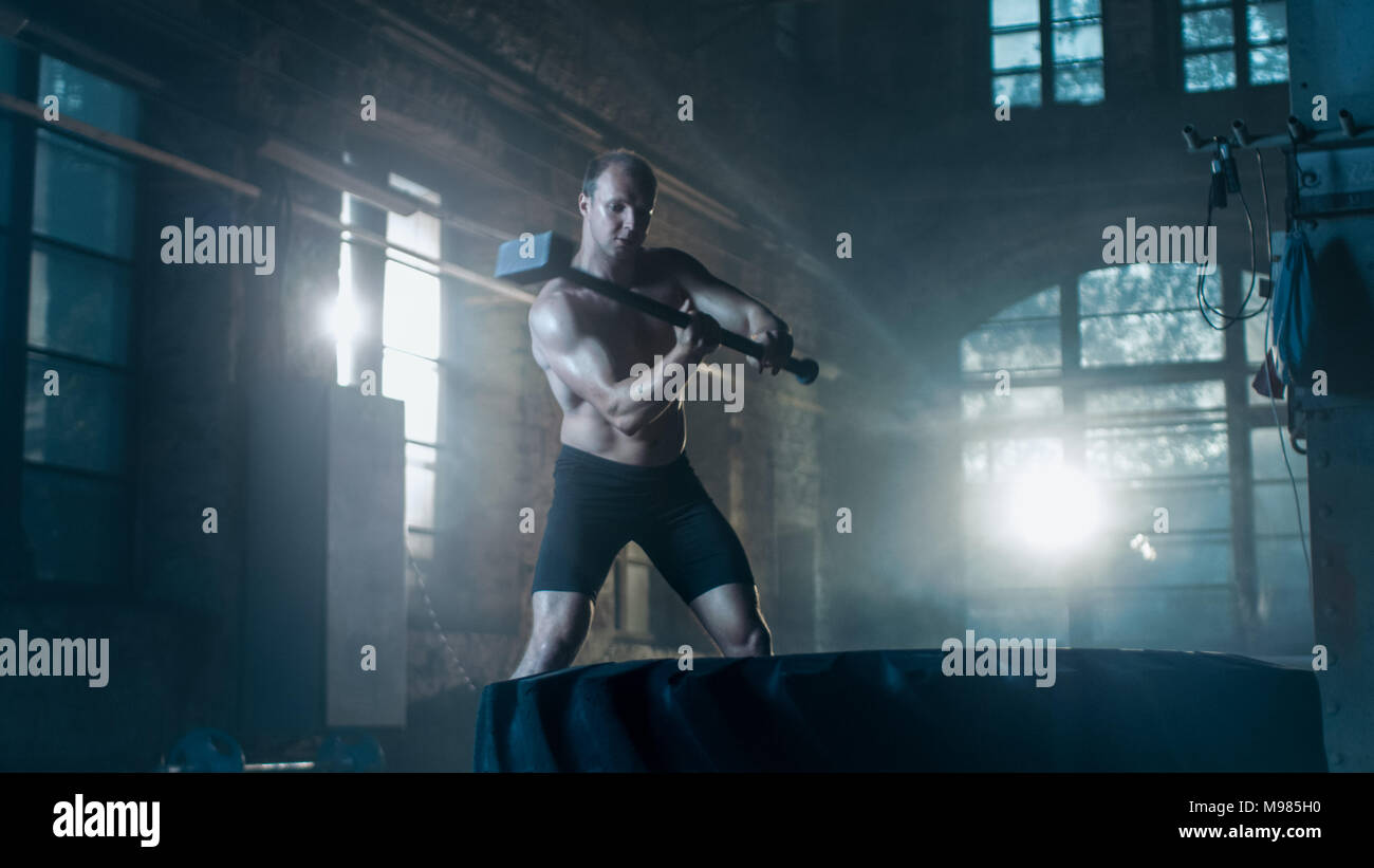 Strong Muscular Man Hits Tire with a Sledgehammer as Part of His Cross ...