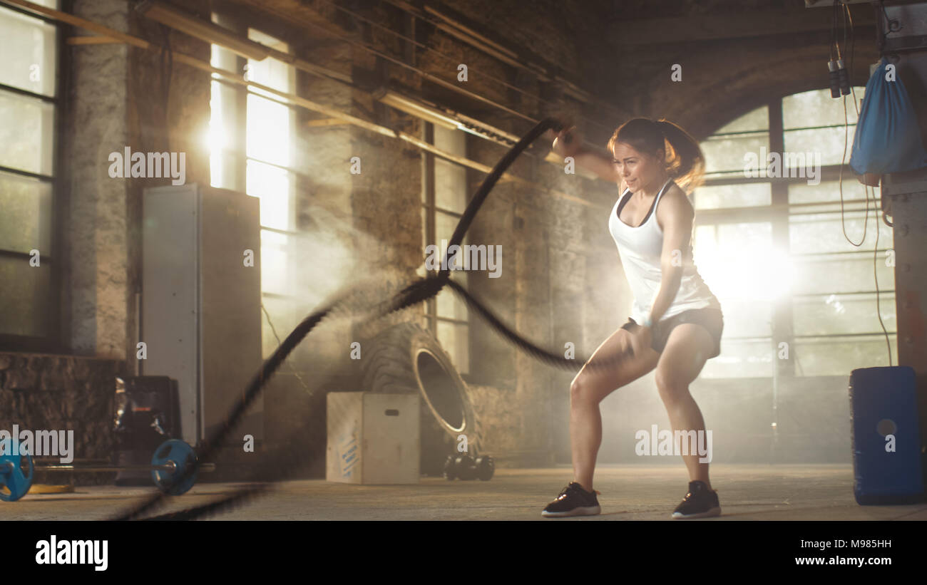 Athletic Female in a Gym Exercises with Battle Ropes During Her Cross ...