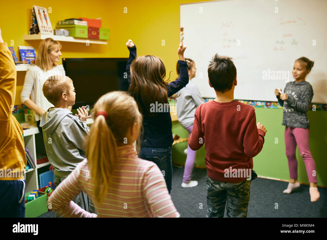 Teacher with students in relaxation room with whiteboard Stock Photo ...
