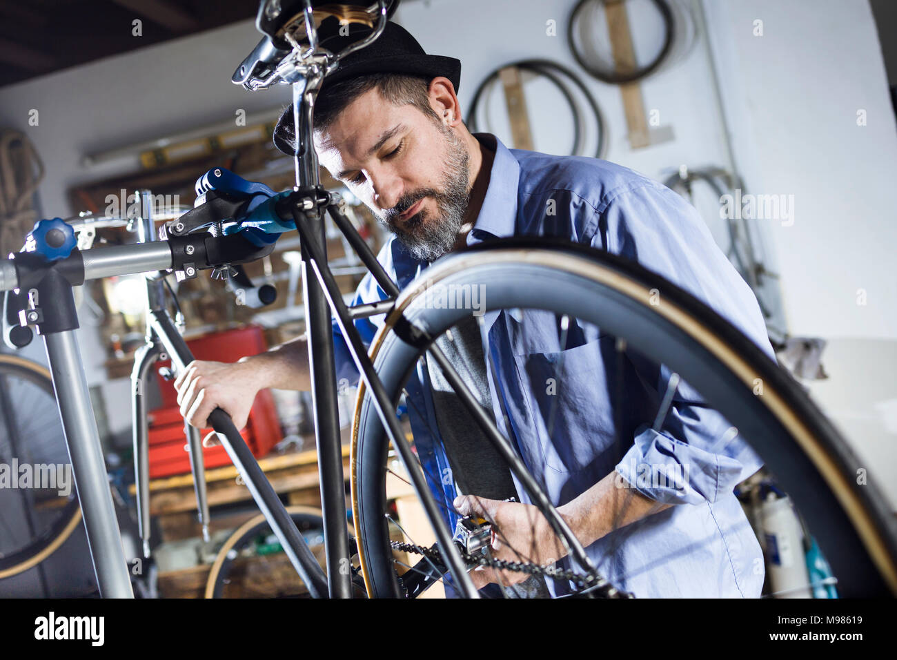 Man working on bicycle in workshop Stock Photo - Alamy