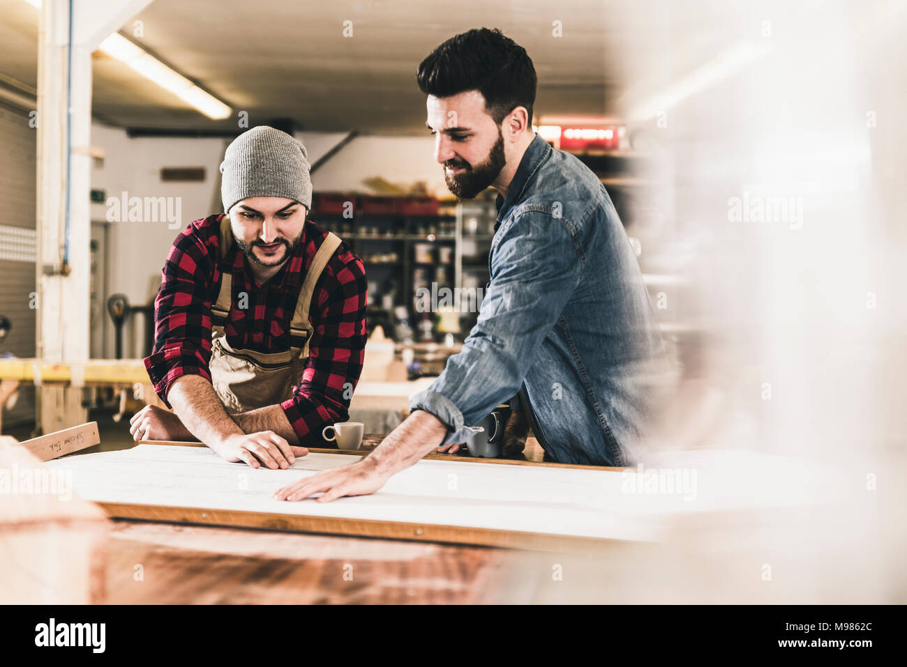 Two men discussing in workshop Stock Photo - Alamy