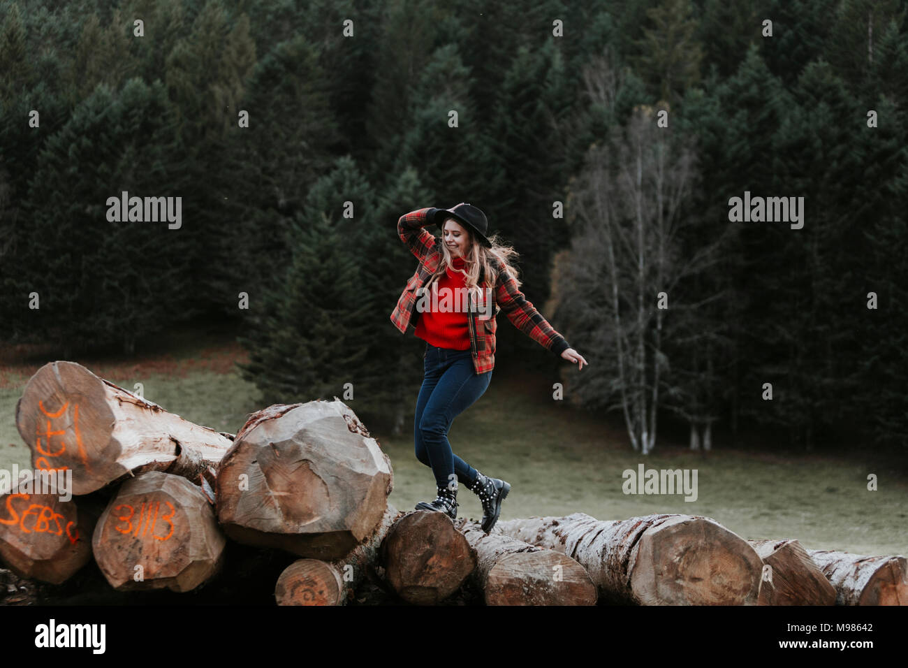 Young woman balancing on logs Stock Photo - Alamy