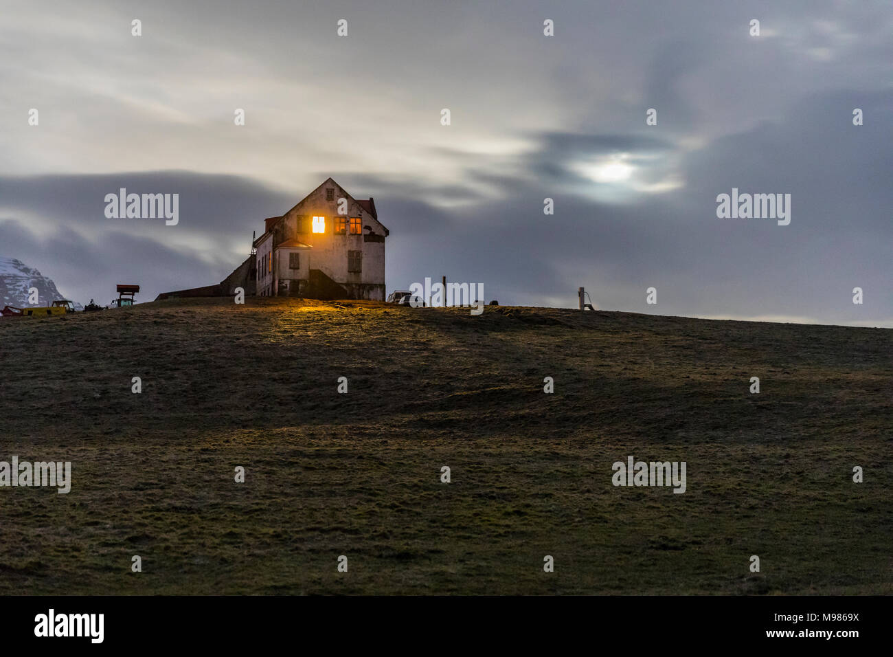 Iceland, Hofn, Illuminated window in a house in the countryside at ...