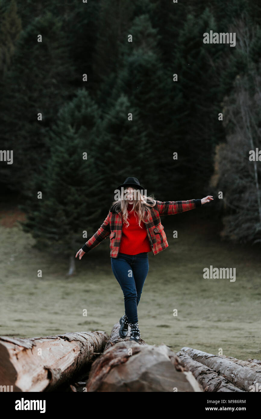 Young woman balancing on logs Stock Photo - Alamy