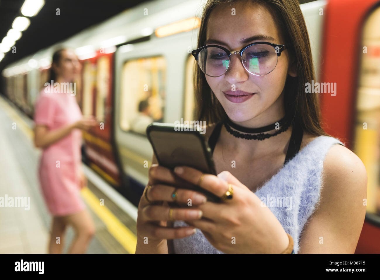 Teenage girl using cell phone at subway station Stock Photo - Alamy