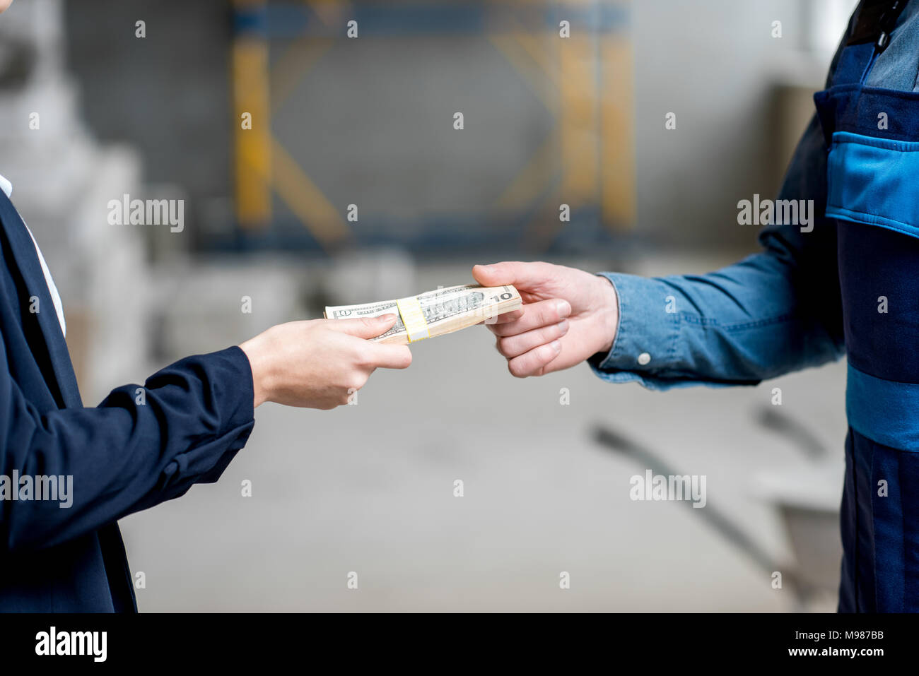 Giving a money to builder indoors Stock Photo - Alamy