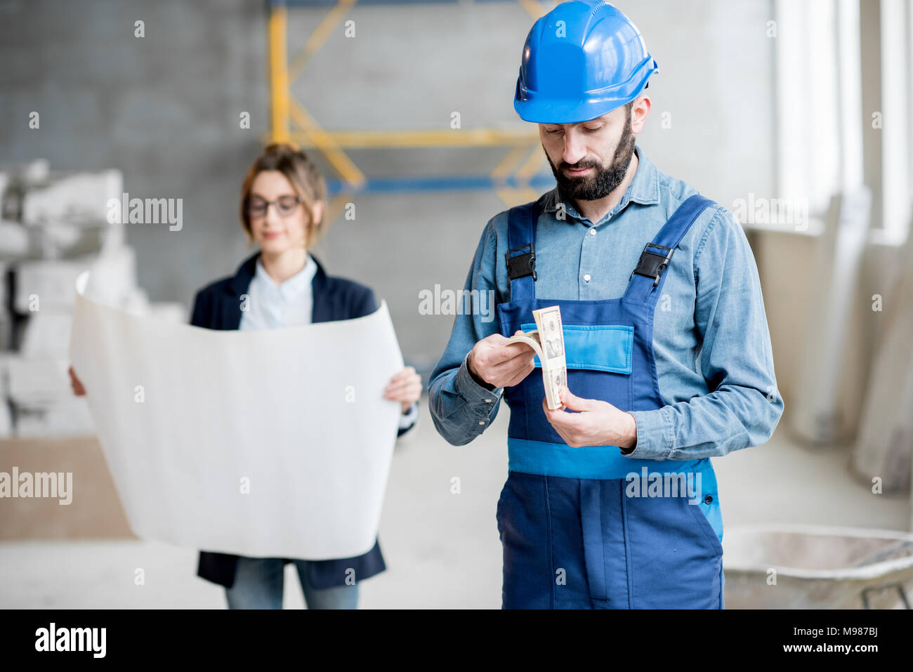 Builder counting money Stock Photo - Alamy