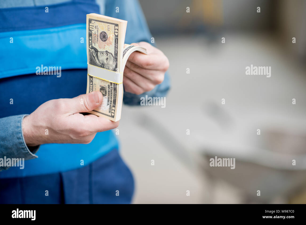 Builder counting money Stock Photo - Alamy