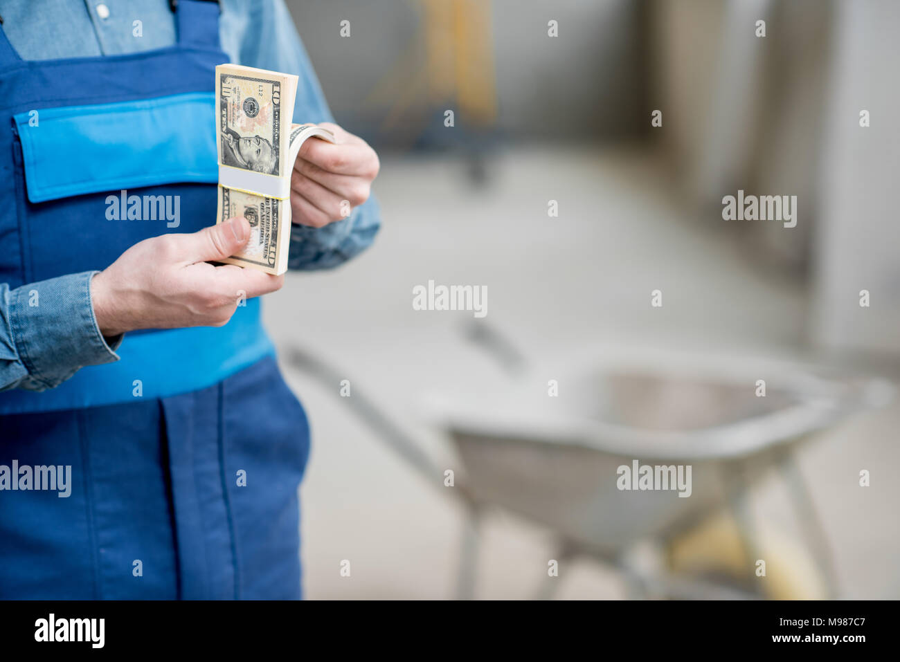 Builder counting money Stock Photo - Alamy