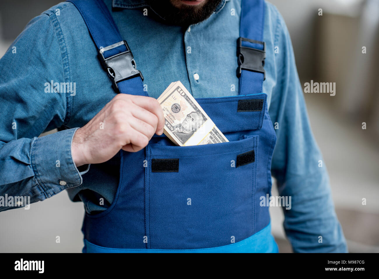 Builder with money at the construction site Stock Photo - Alamy