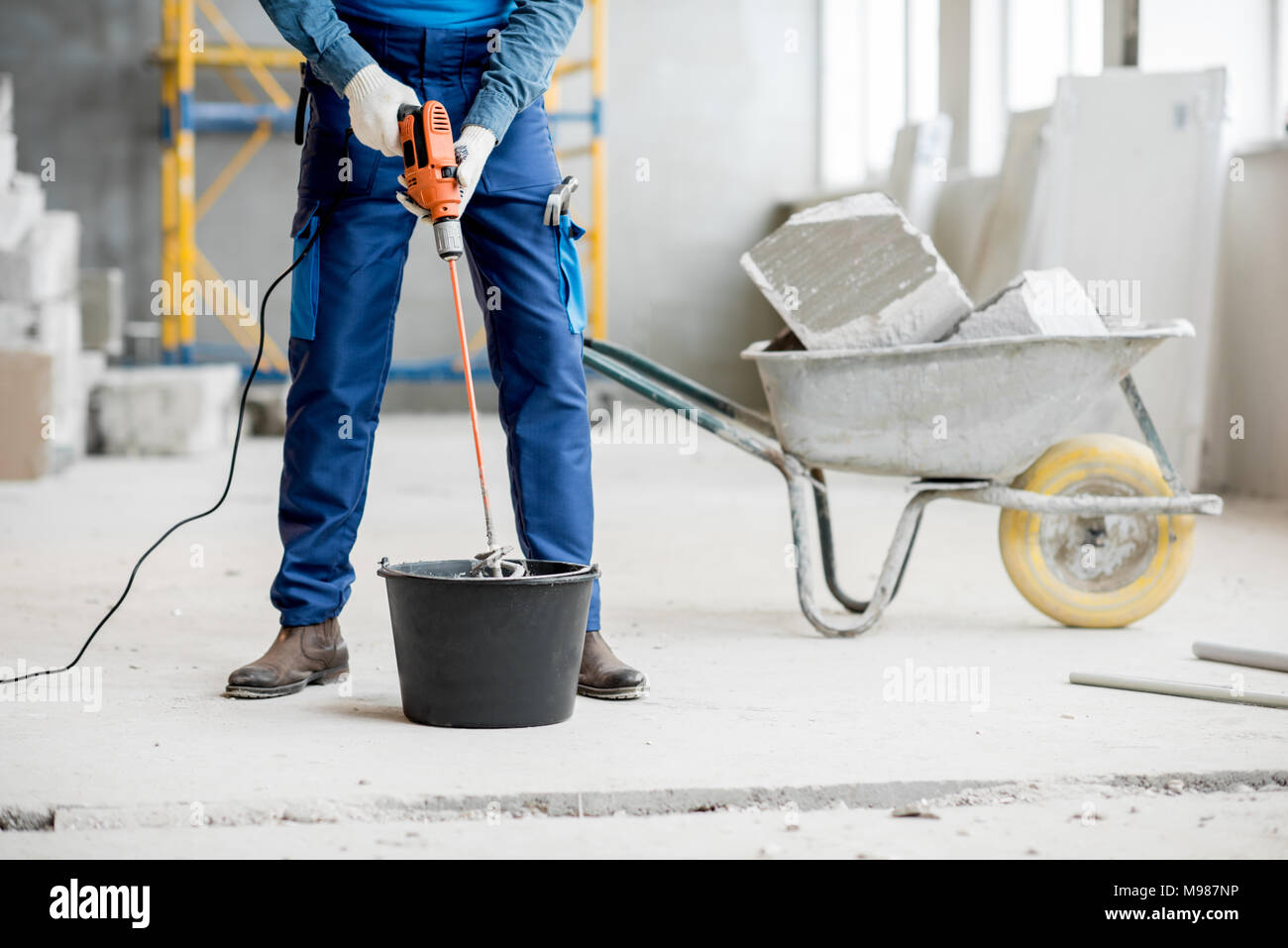 Builder mixing plaster at the construction site Stock Photo - Alamy