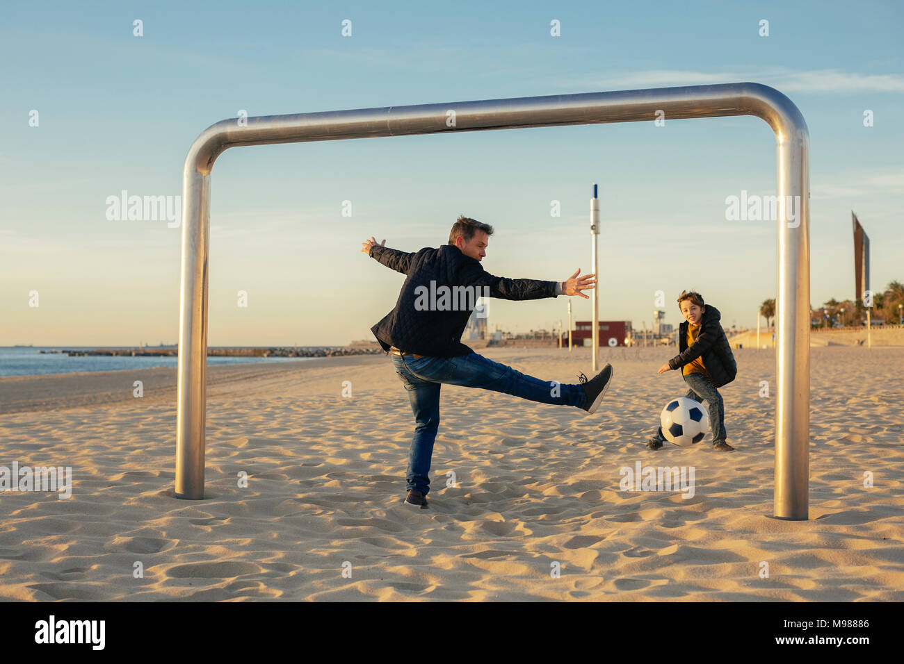Men playing football on beach hi-res stock photography and images - Alamy