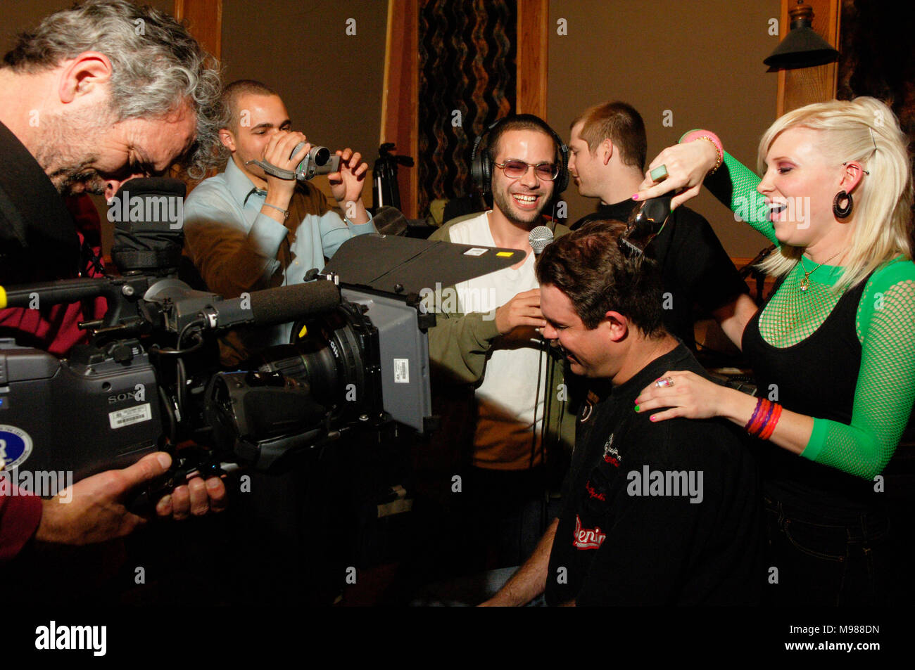 Singer Lucy Walsh (r) gives a hair cut while being filmed as host Stu ...
