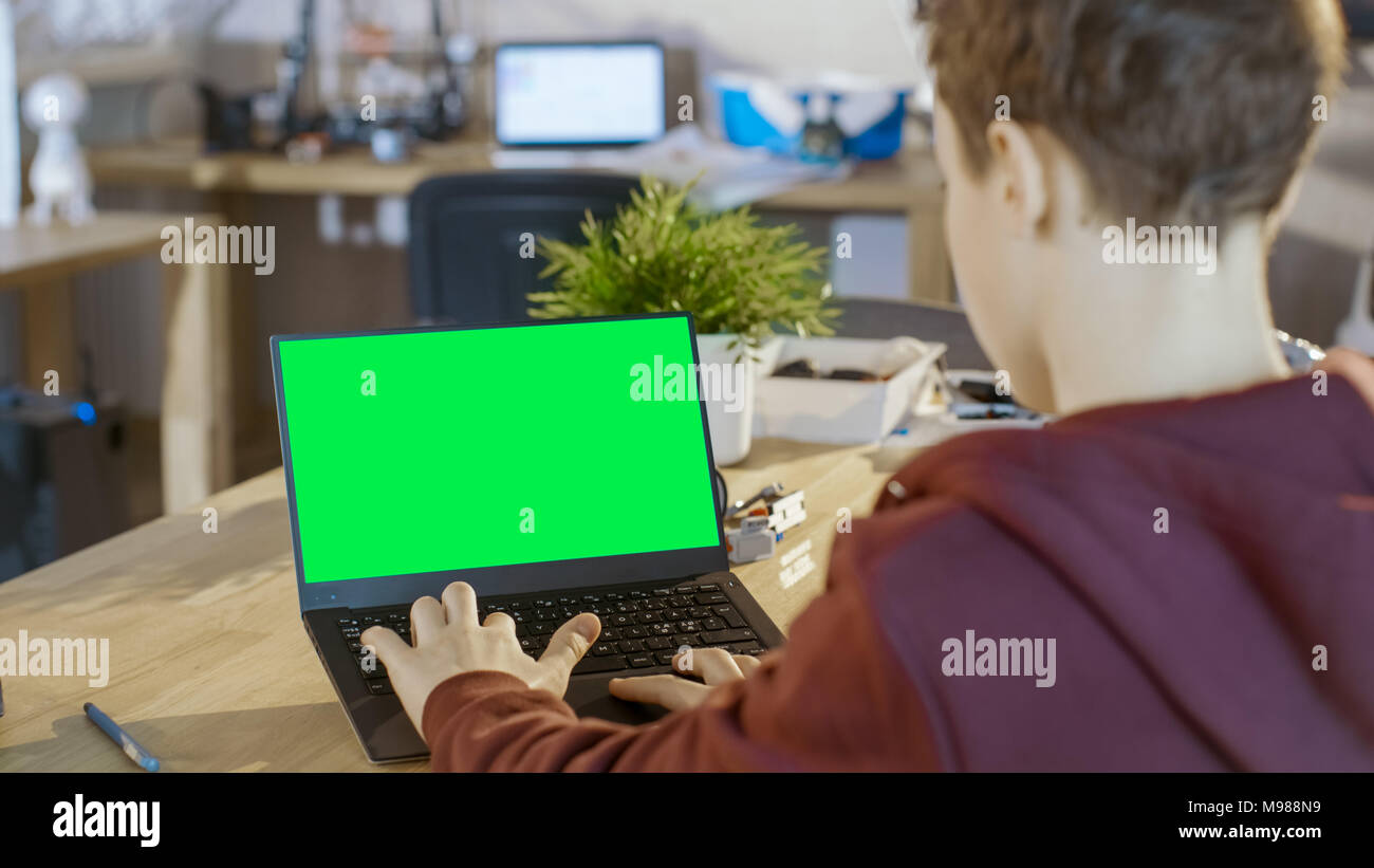 Smart Boy Uses Laptop with Mock-up Green Screen in His Computer Science ...