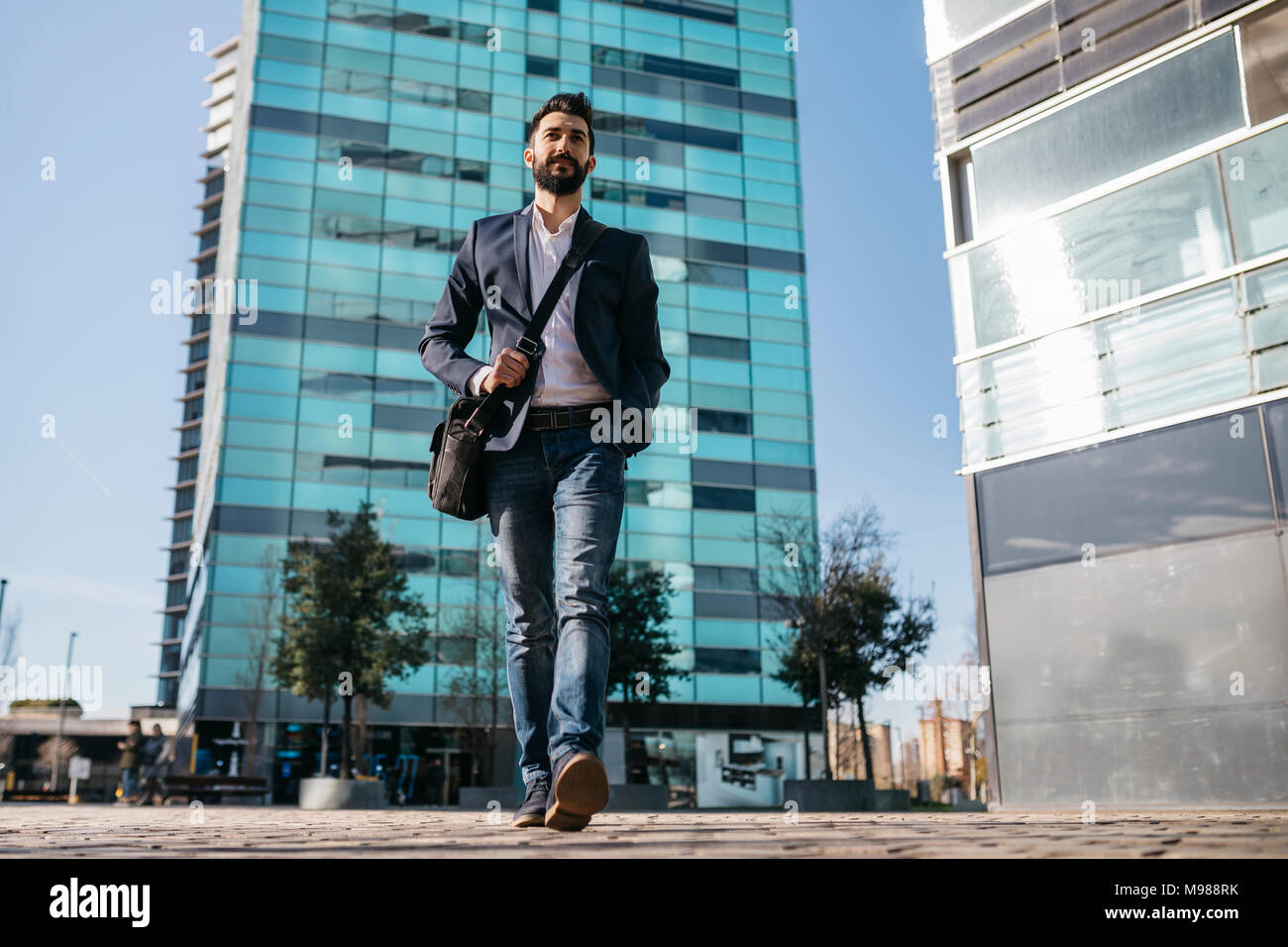 Businessman walking outside office building Stock Photo - Alamy