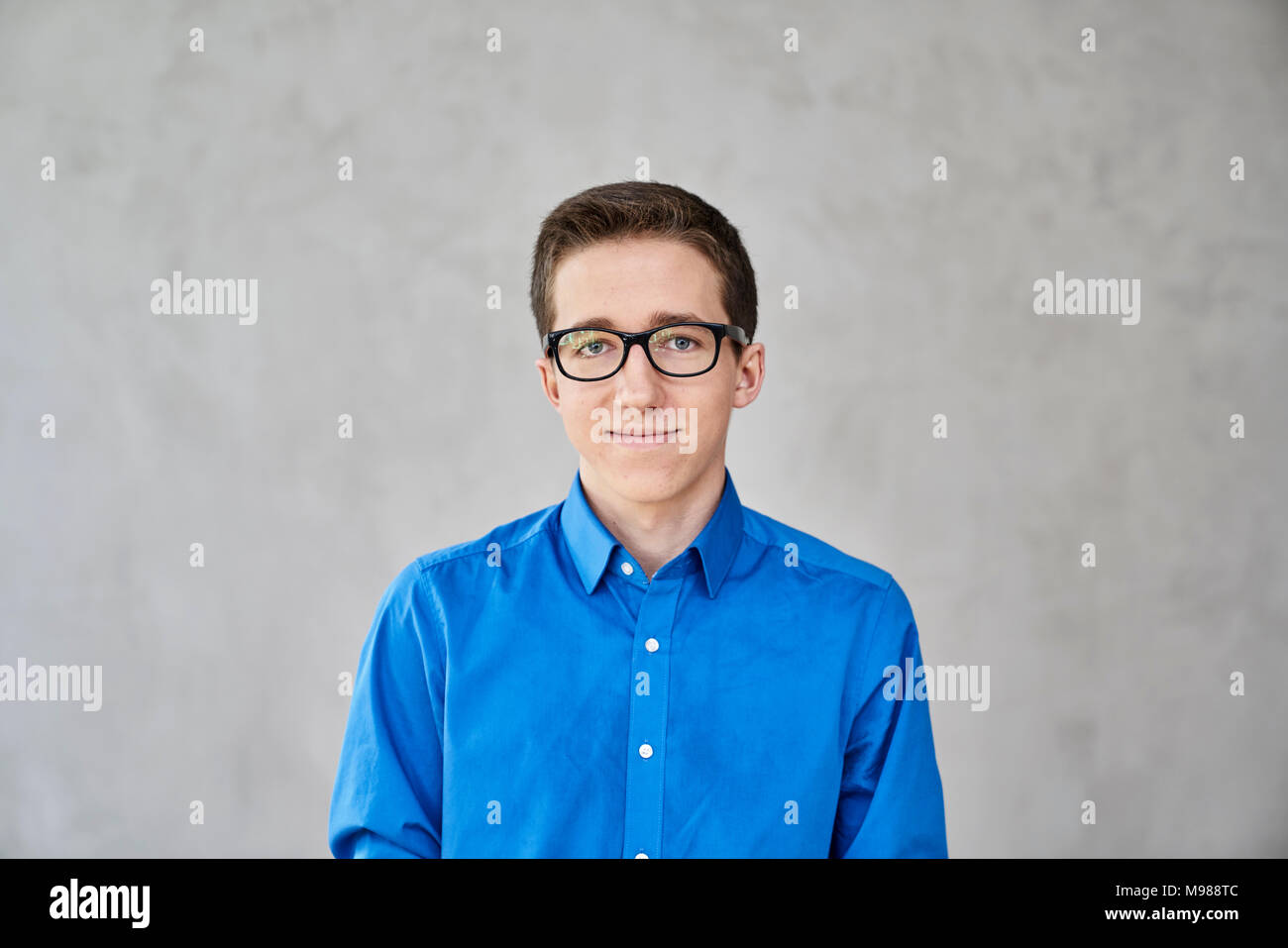 Portrait of confident young man wearing blue shirt Stock Photo - Alamy