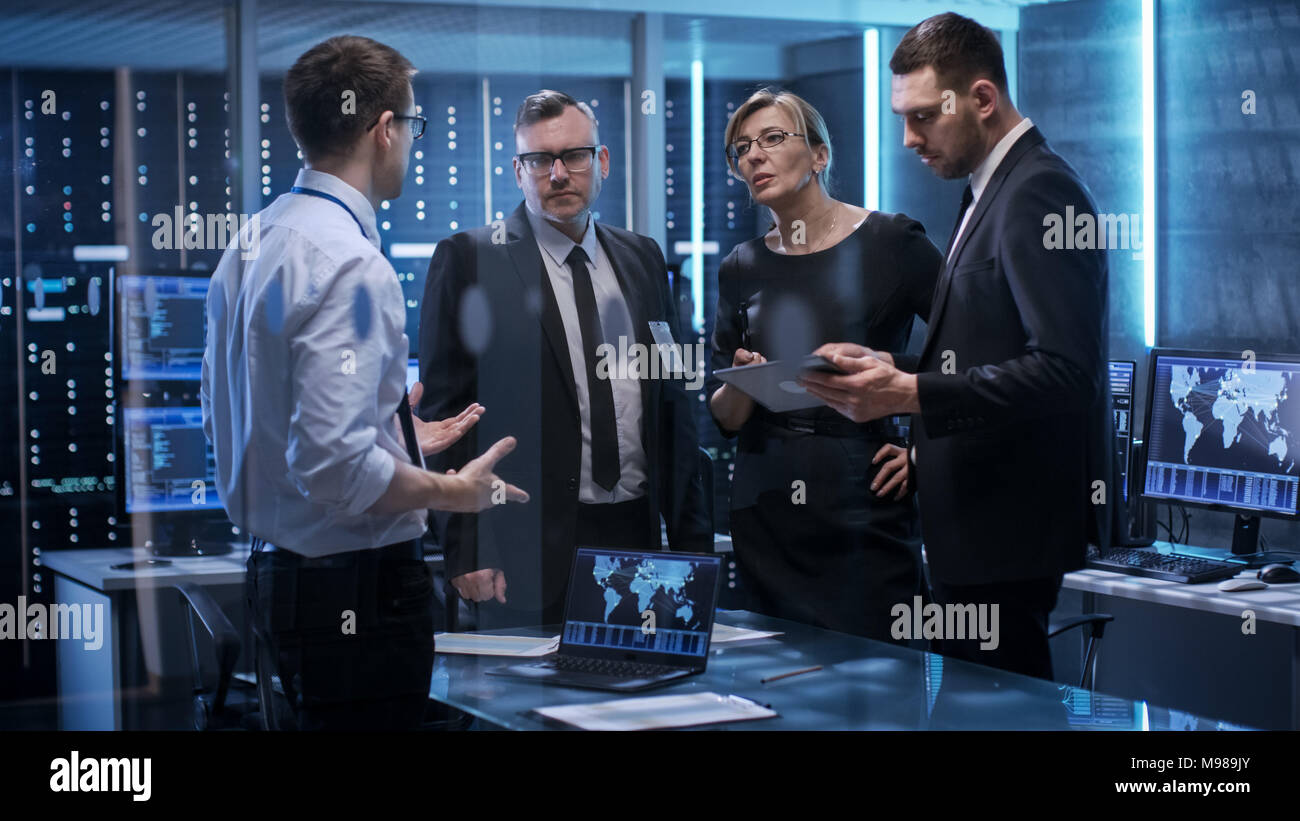 Team of Corporate Managers Having Meeting in Monitoring Room. They're ...