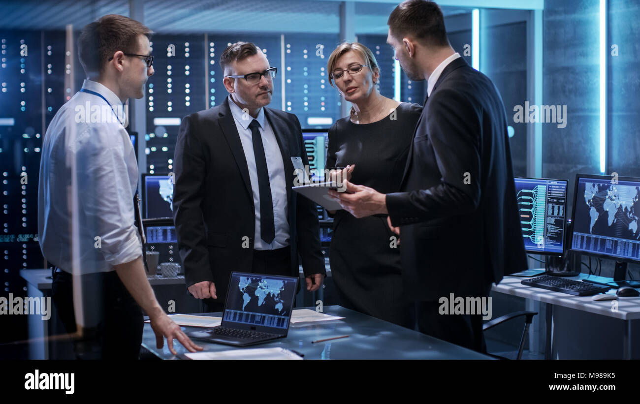 Team of Corporate Managers Working at the Table in Monitoring Room ...