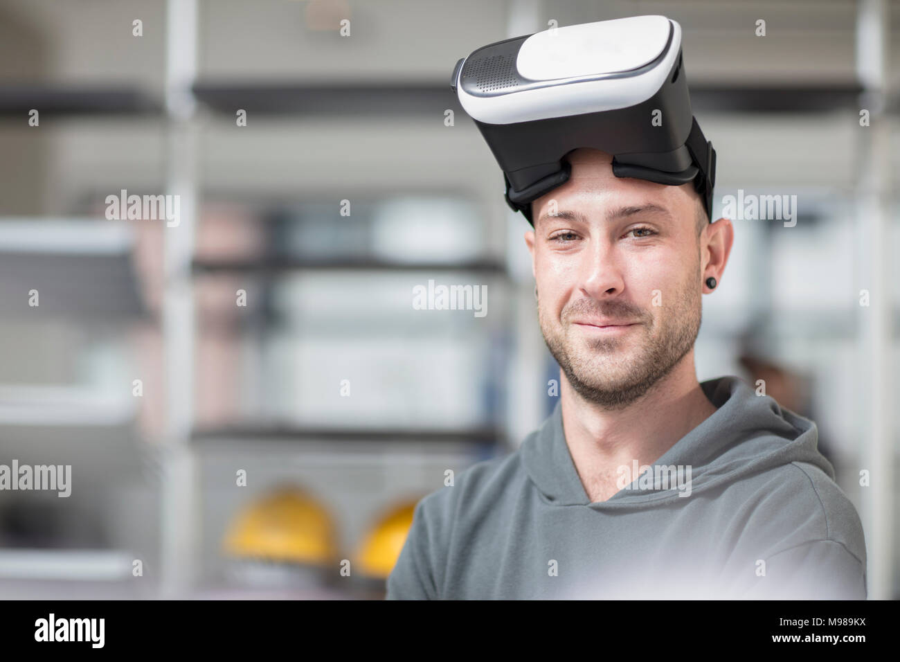 Portrait of smiling young man wearing VR glasses in office Stock Photo ...
