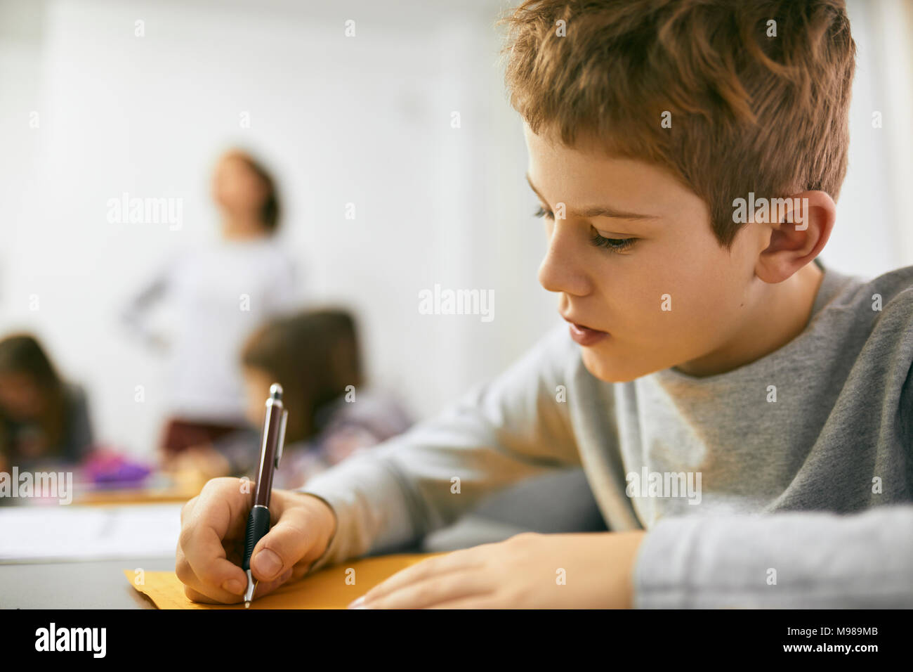 Child writing in class hi-res stock photography and images - Alamy