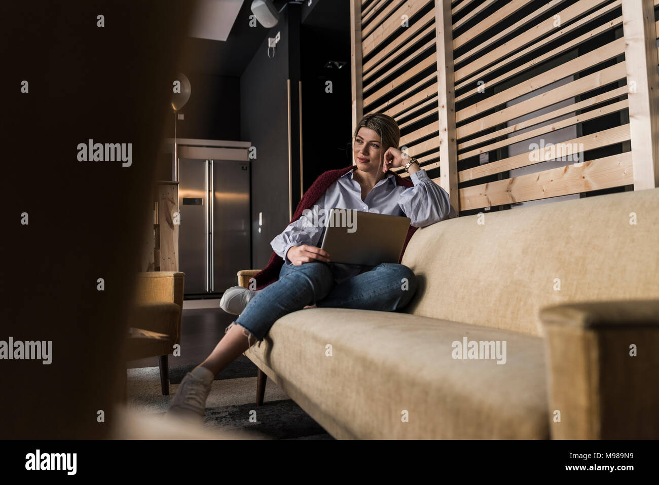 Woman Sitting Sideways On Couch High Resolution Stock Photography and ...