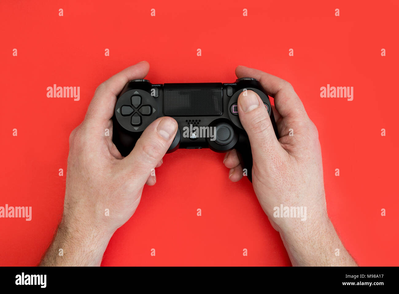 LONDON - MARCH 22, 2018: Man playing video games holding PlayStation ...
