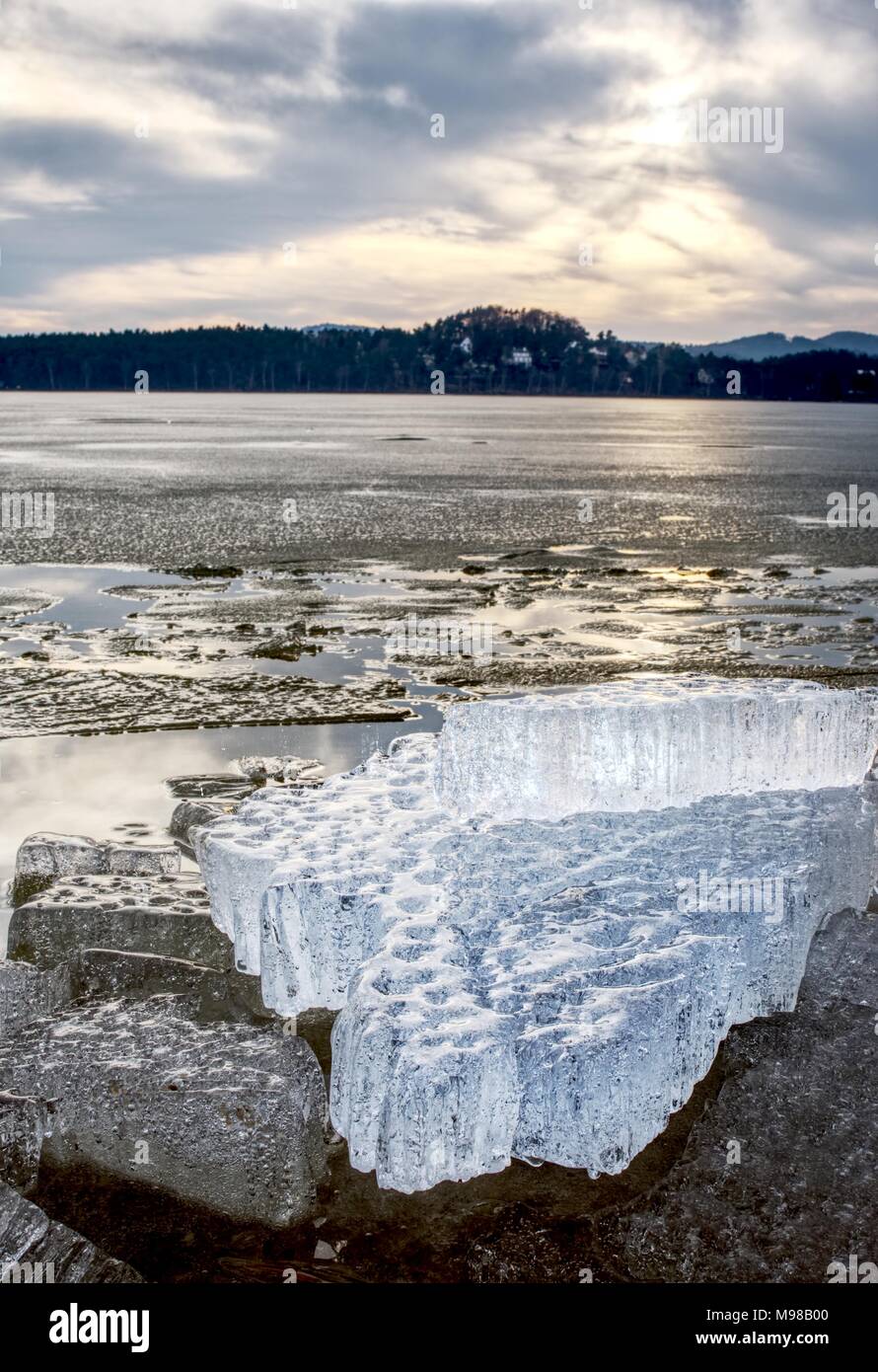 Exposed shore under melting ice. Close up view to border between ice ...