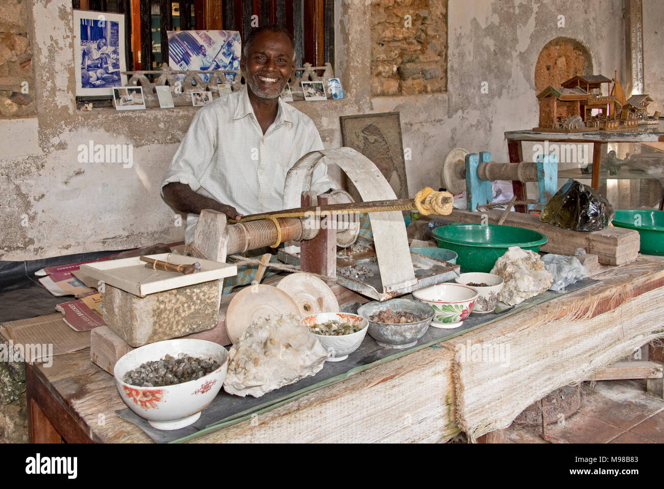 A happy smiling male man artisan Sri Lankan worker polishing gem stones ...