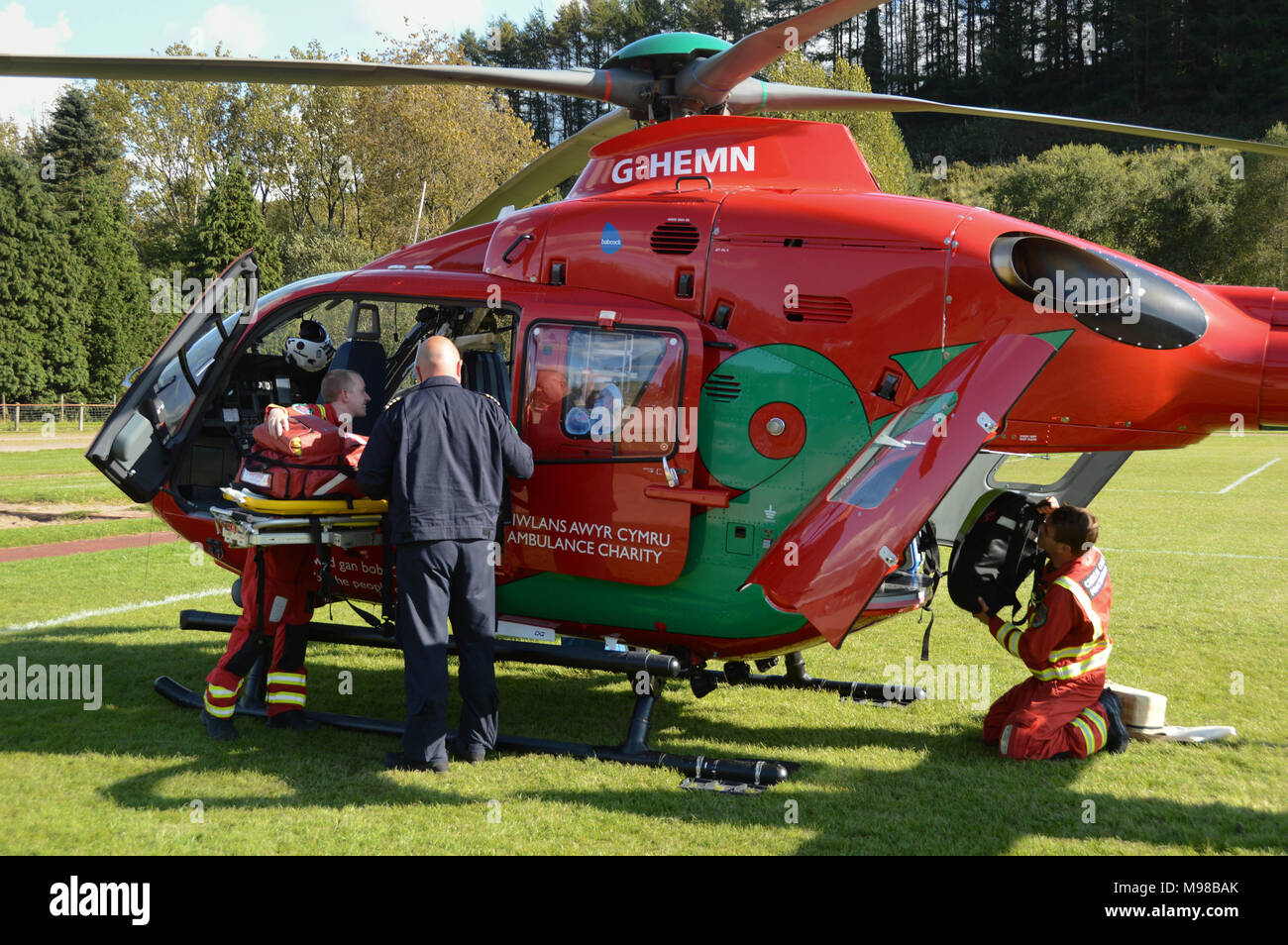 Crew members preparing a helicopter of the Wales Air Ambulance for take ...
