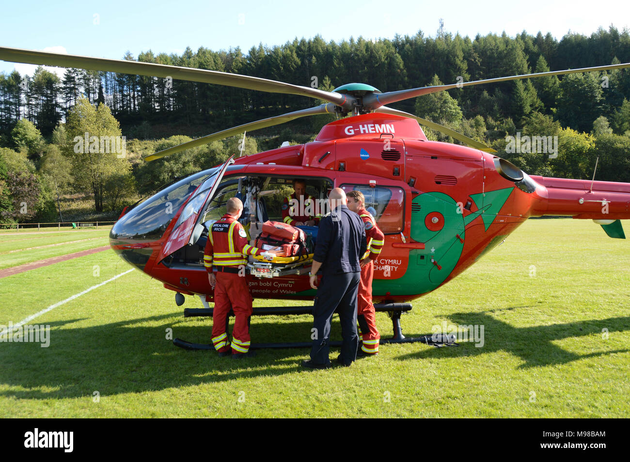 Crew members standing outside an Airbus helicopter of the Wales Air ...