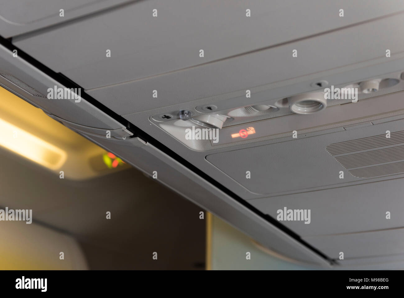 No Smoking Sign inside an airplane. Overhead console in the passenger ...