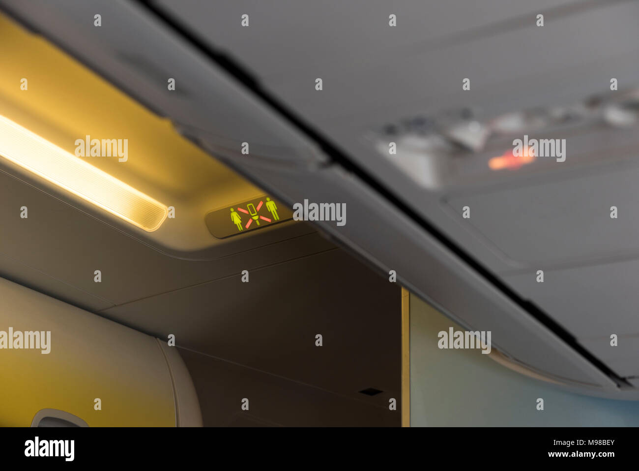 Fasten Seatbelt Sign inside an airplane. Overhead console in the ...