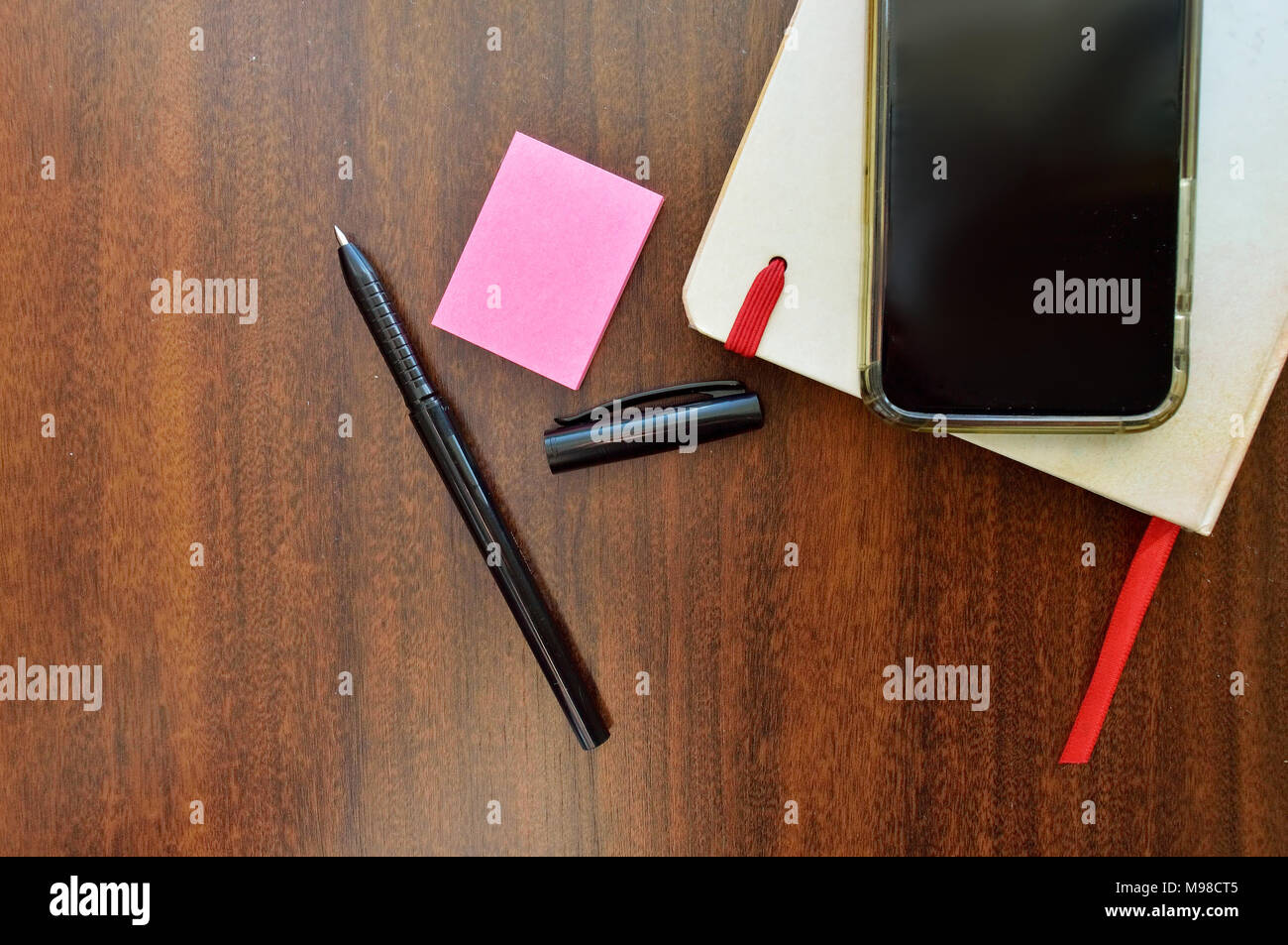Pen, sticky notes, notebook and mobile phone on a wood desk Stock Photo ...
