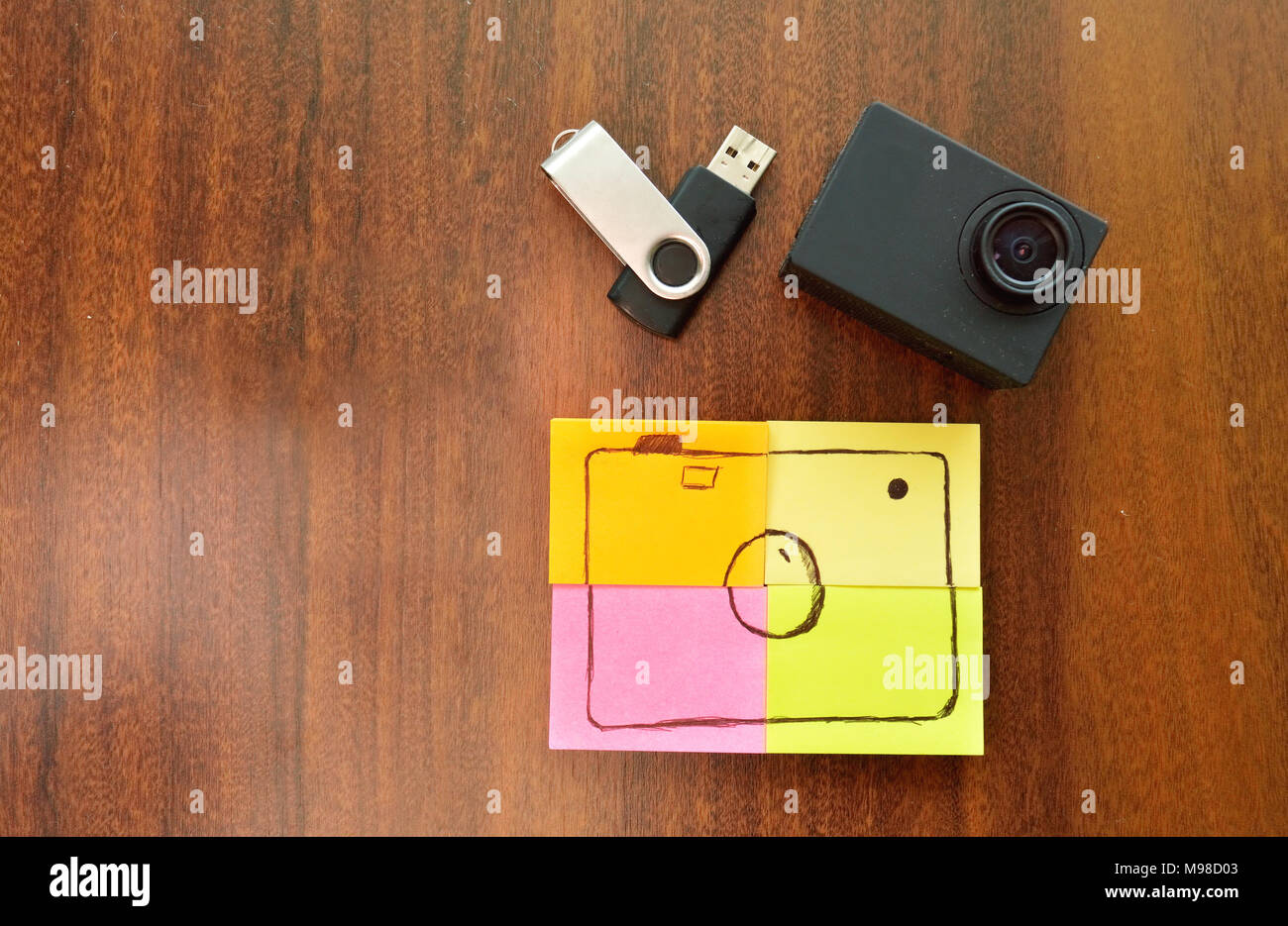 Sticky notes with a camera drawing along with a pen drive and an action ...
