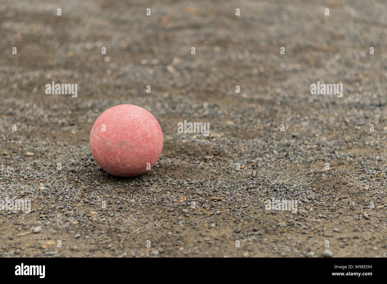 Single Red Bocce Ball Copy Space Right over gravel surface Stock Photo ...