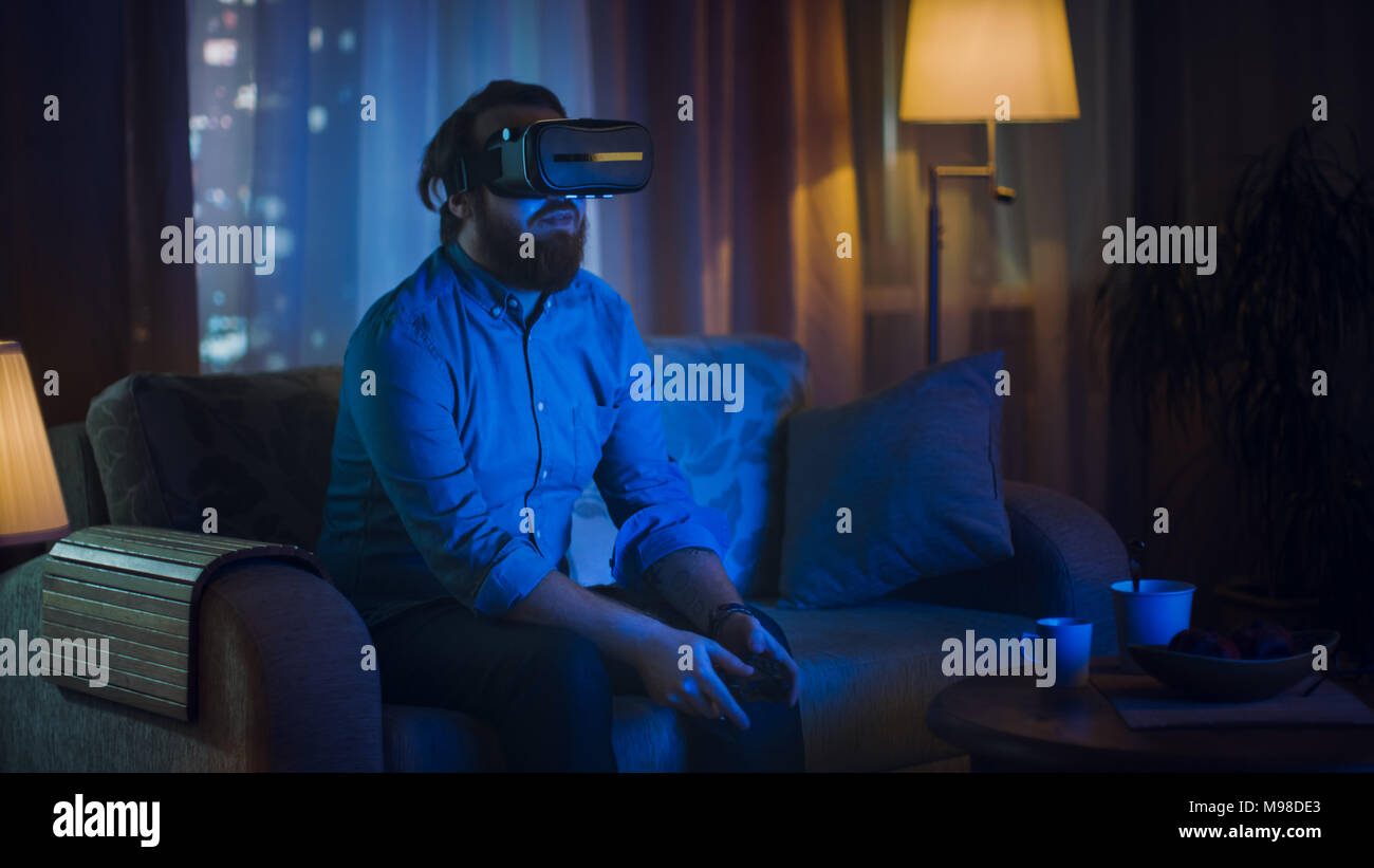 Man Sitting on a Couch in His Living Room Wearing Plays Video Games on ...