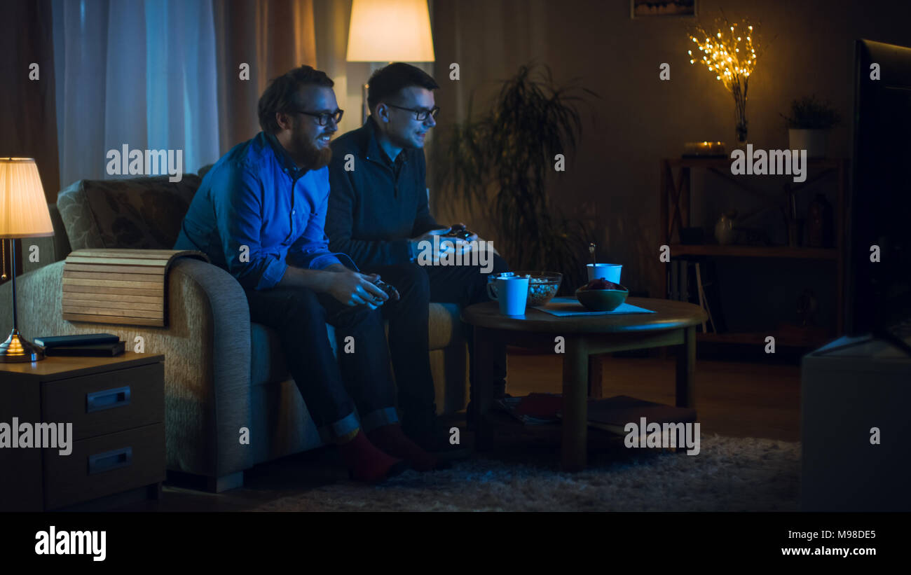 In the Evening Two Friends are Sitting on a Sofa in the Living Room and Playing Competitive ...