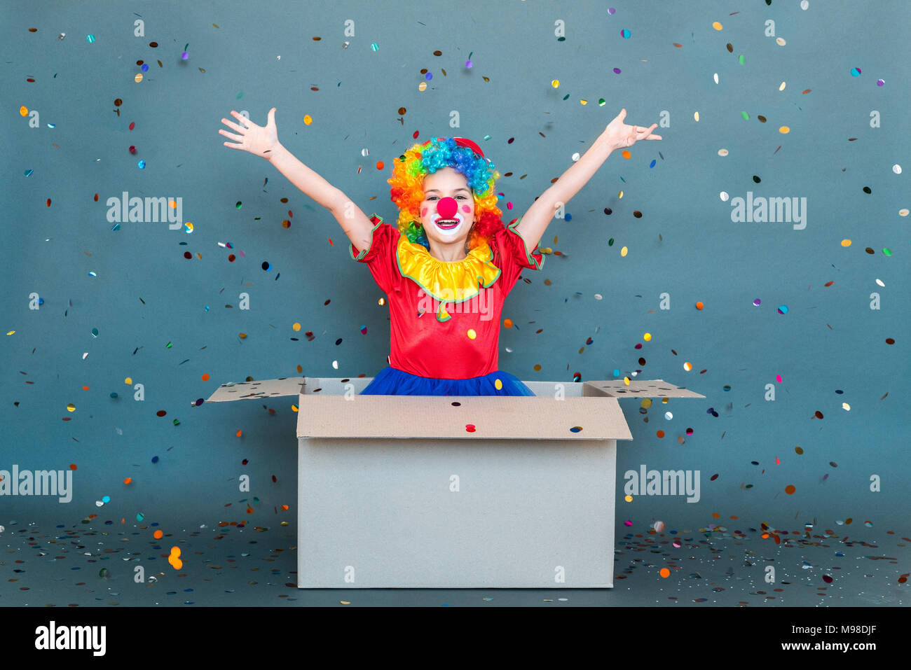 Happiness little clown jumping out of the box, toothy smiling. Studio ...