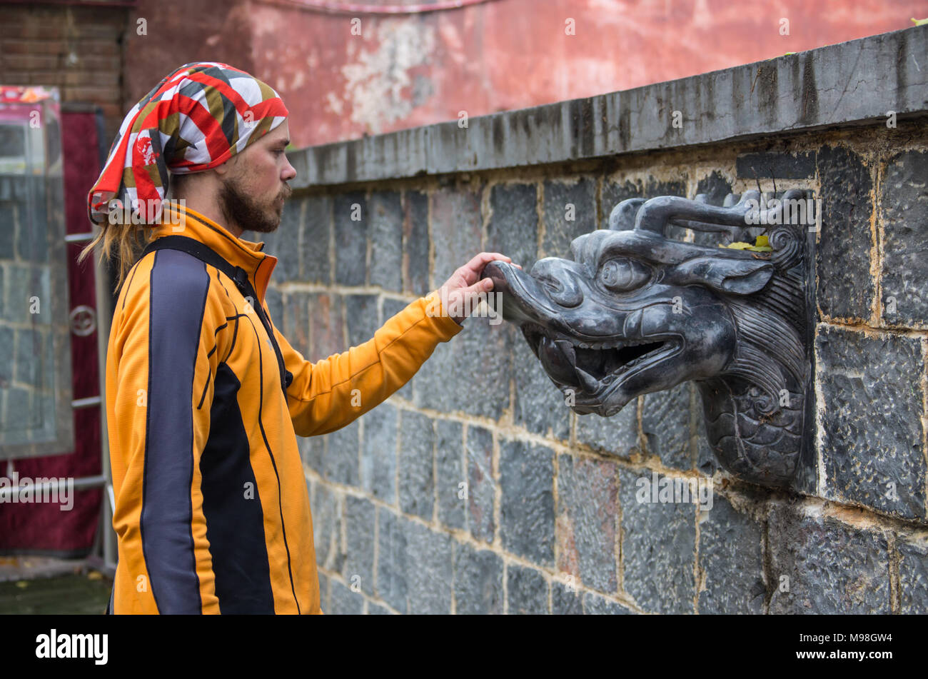 Man with a japanese stone dragon in manastery Stock Photo - Alamy