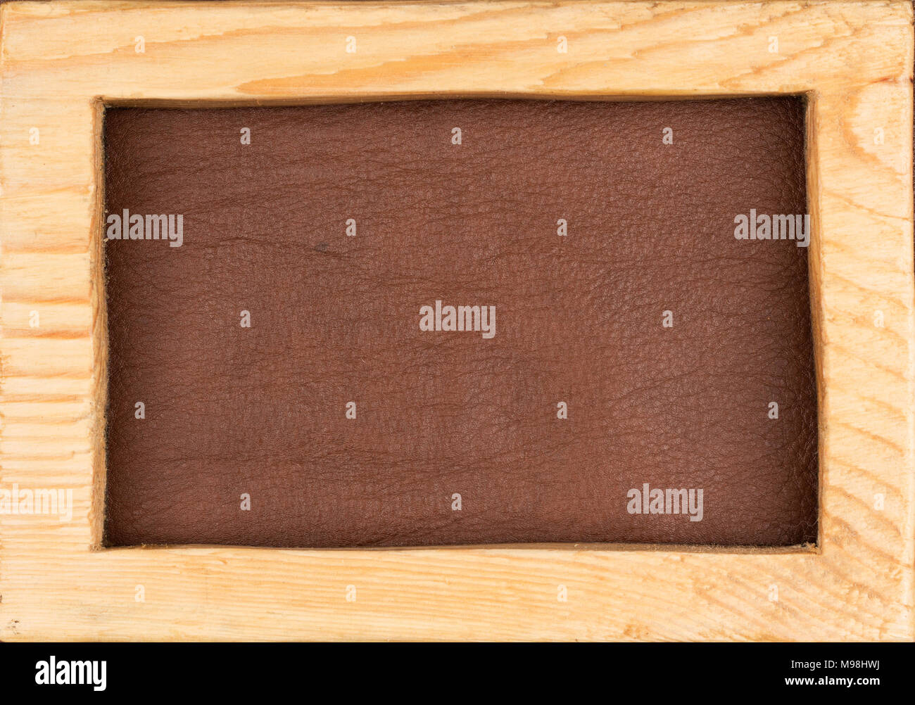 Rectangular frame made from light wood lies on brown natural leather ...