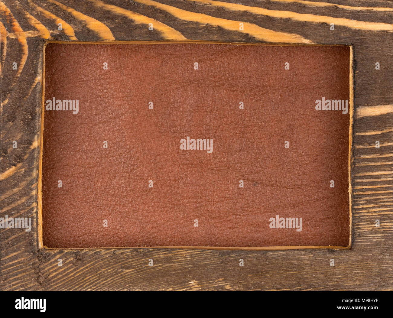 Rectangular frame made of dark wood lies on brown natural leather ...