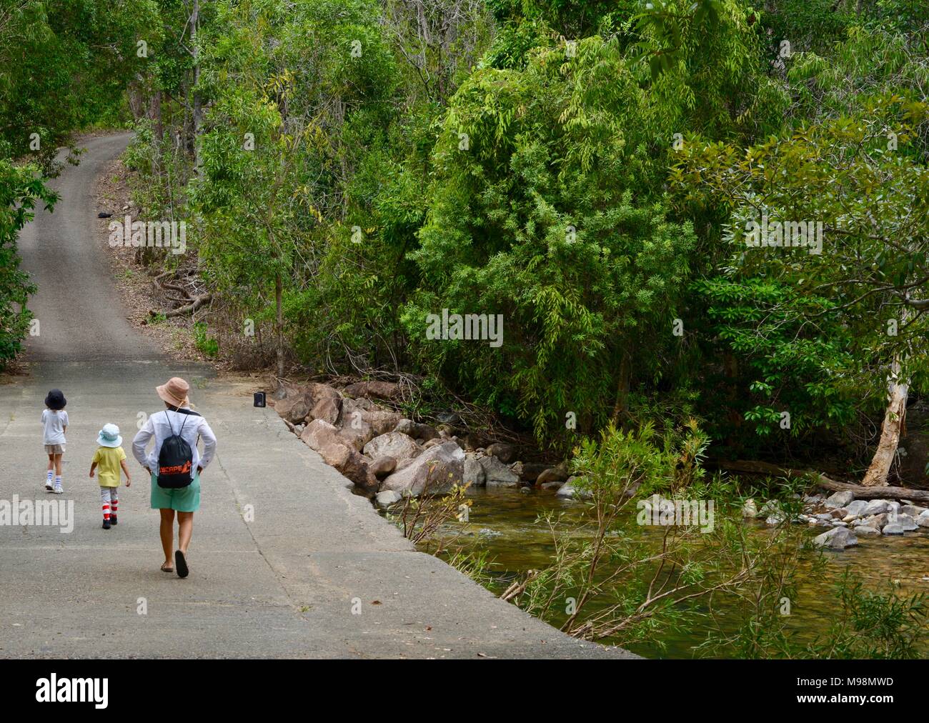 Mother and two children walking through an australian tropical ...