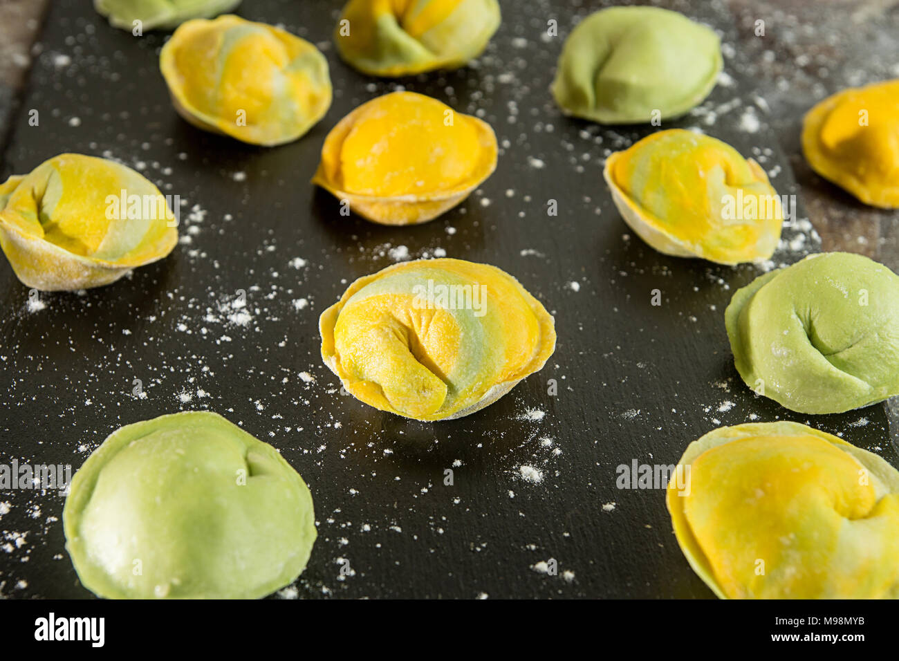 Homemade raw dumpling, yellow and green colors, traditional East ...
