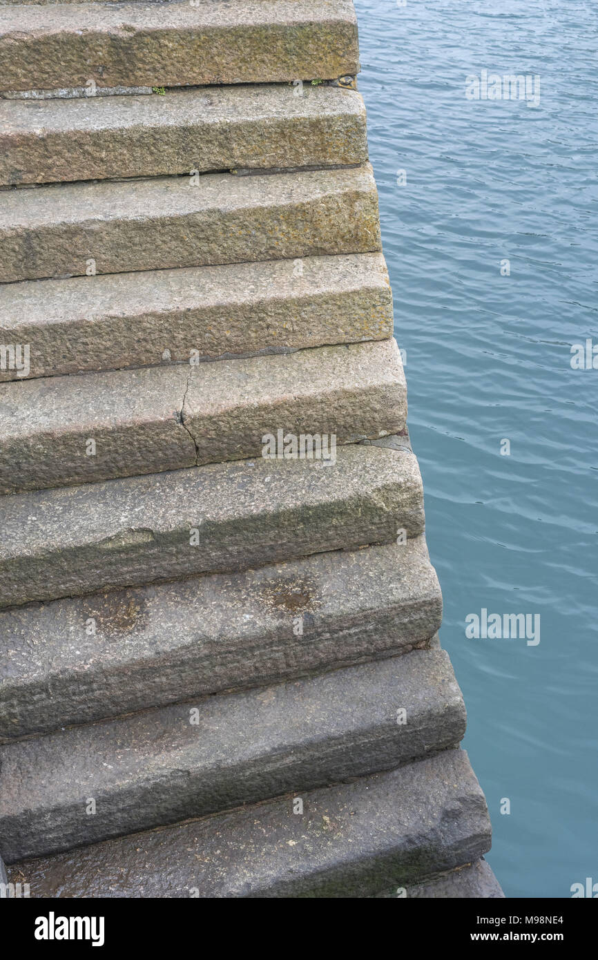 Stone steps leading down to harbour water in Plymouth, Devon. Metaphor ...