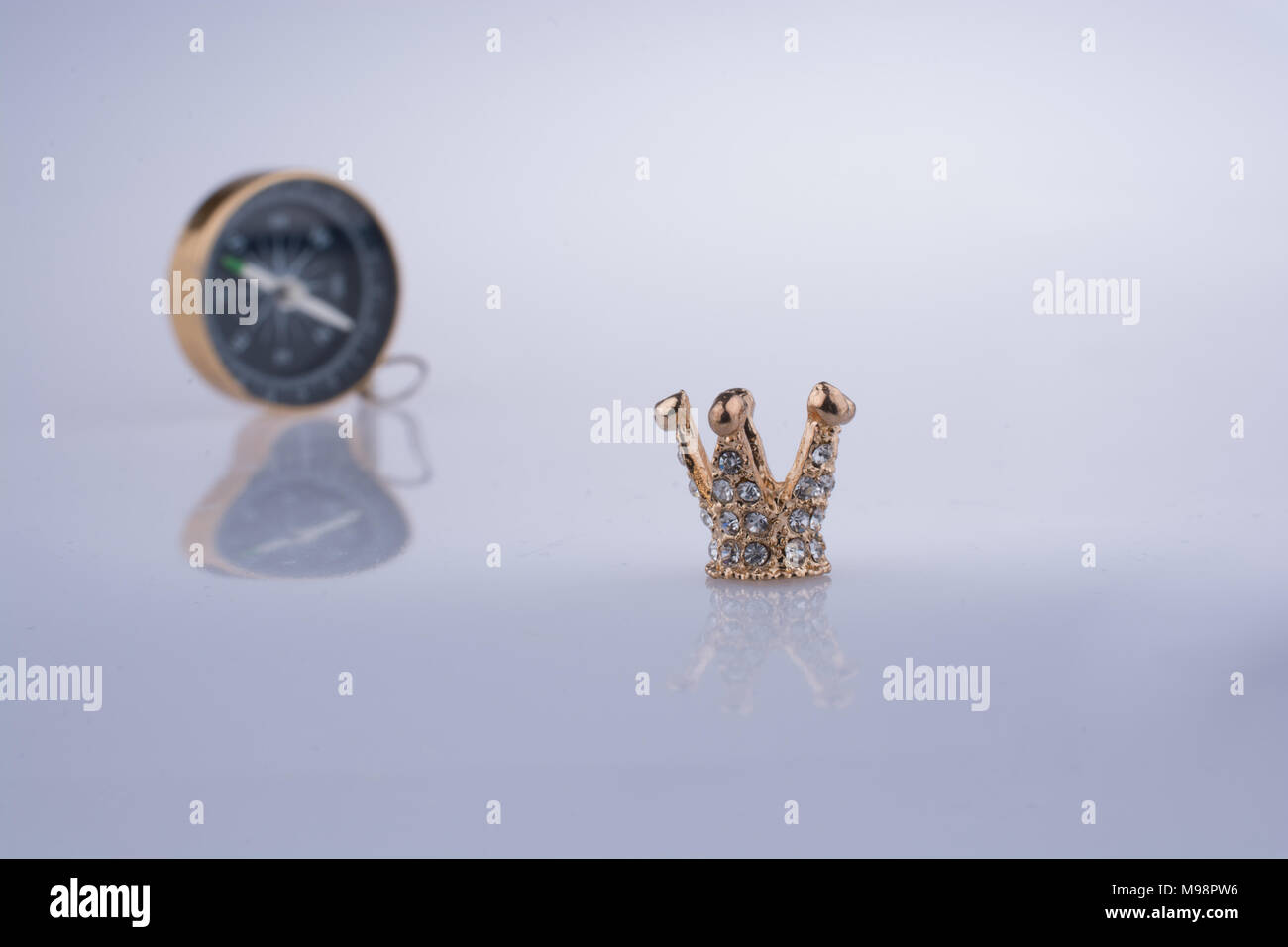 Compass and Golden color crown model with pearls on white background ...