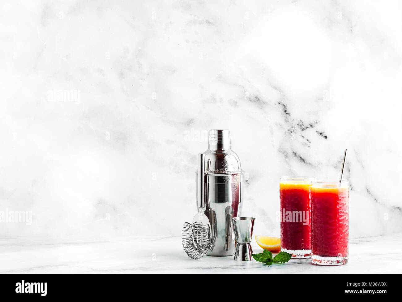 mixing tequila sunrise in a shaker on a marble table, copy space Stock ...