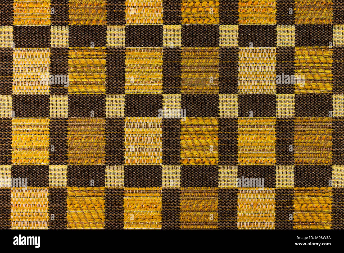 Fabric with a yellow - brown background with geometric patterns. Close ...
