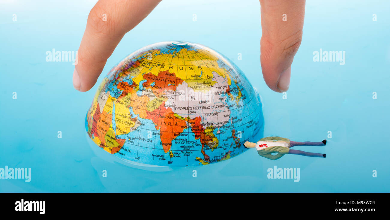 Little globe with floating figurines around in water Stock Photo - Alamy