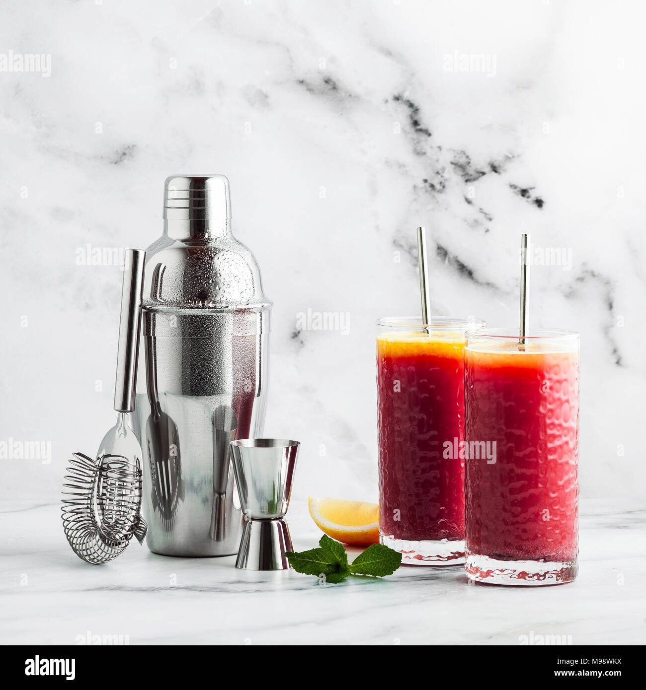 mixing tequila sunrise in a shaker on a marble table, copy space Stock ...